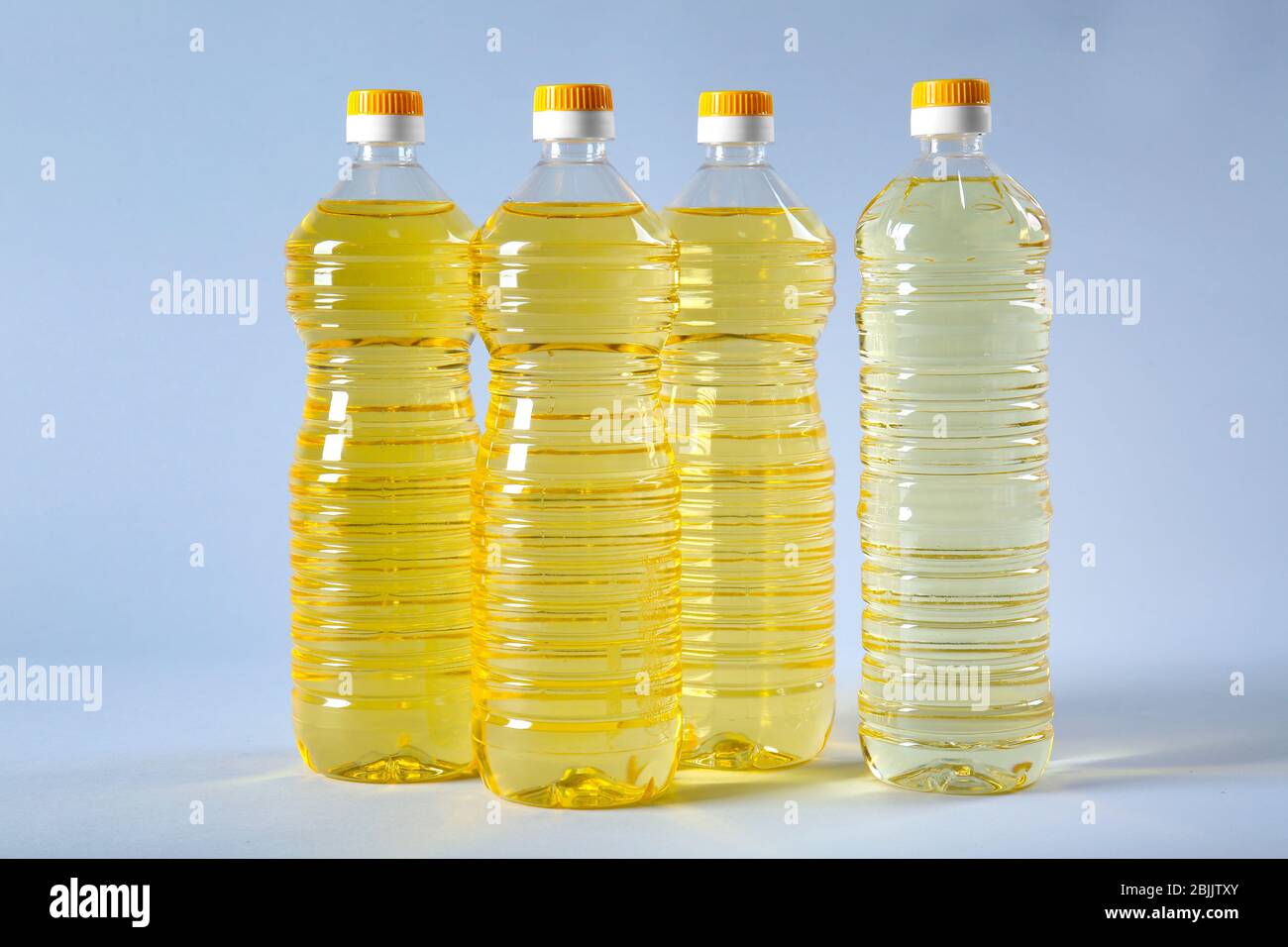 Bottles of cooking oil on light background Stock Photo - Alamy