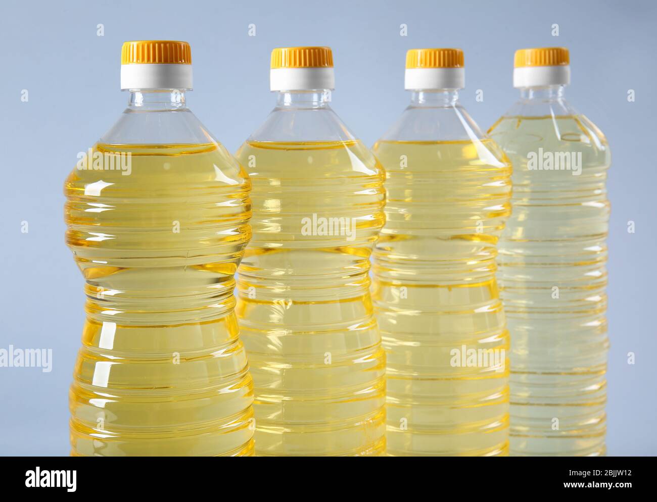 Bottles of cooking oil on light background Stock Photo - Alamy