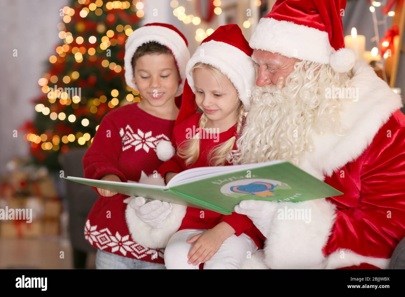 Authentic Santa reading book to cute kids in room with beautiful ...