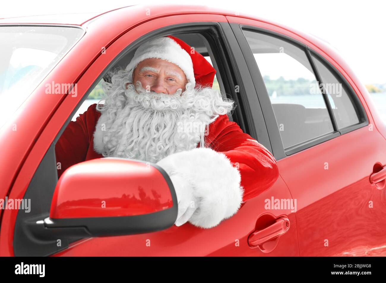 Authentic Santa Claus looking out of car window Stock Photo - Alamy