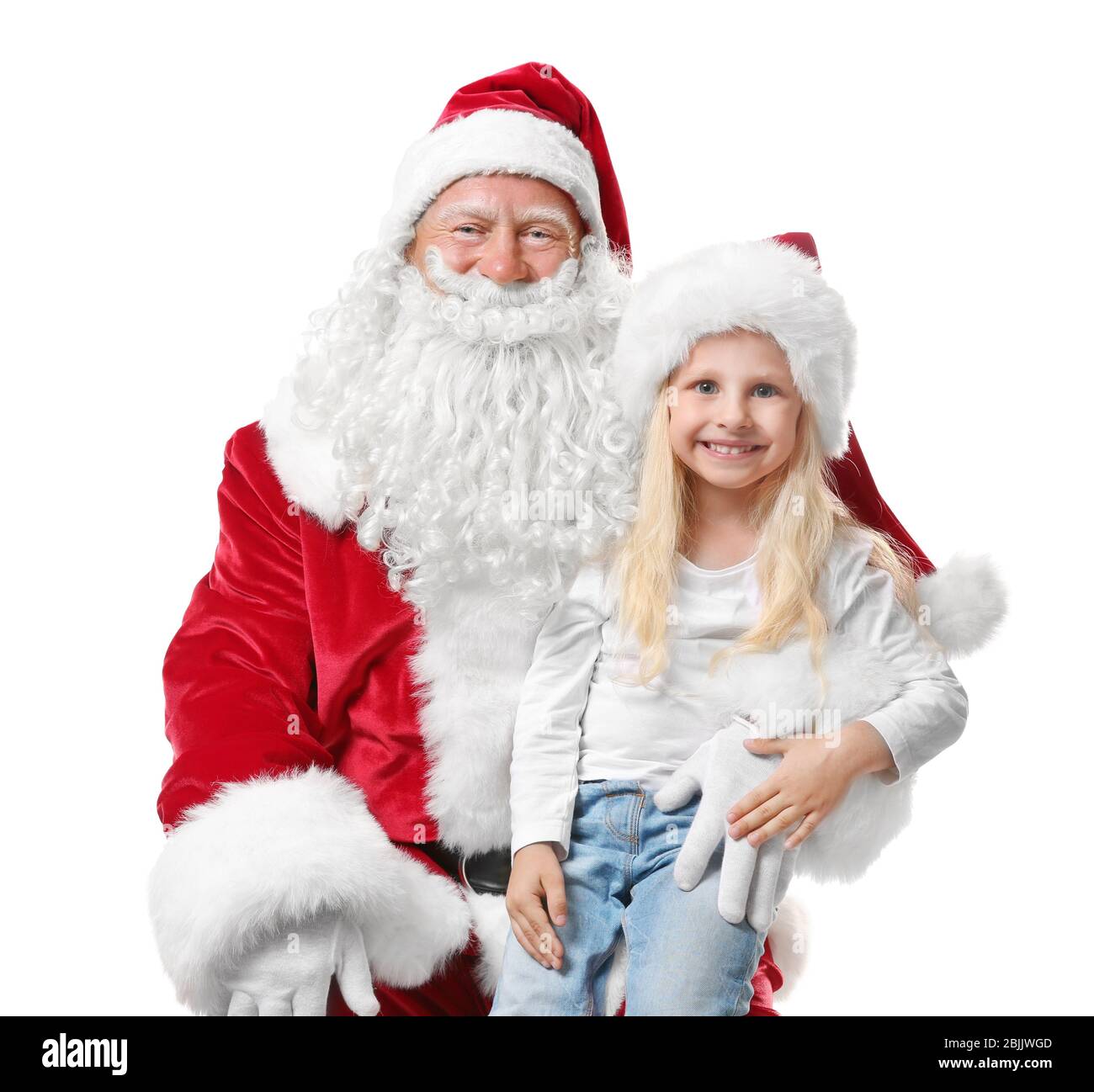 Cute little girl in Christmas hat sitting on Santa's lap against white ...