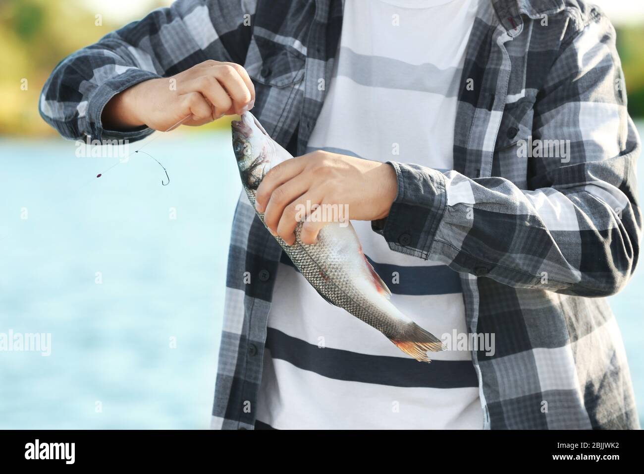 Man holding freshly caught fish Stock Photo - Alamy