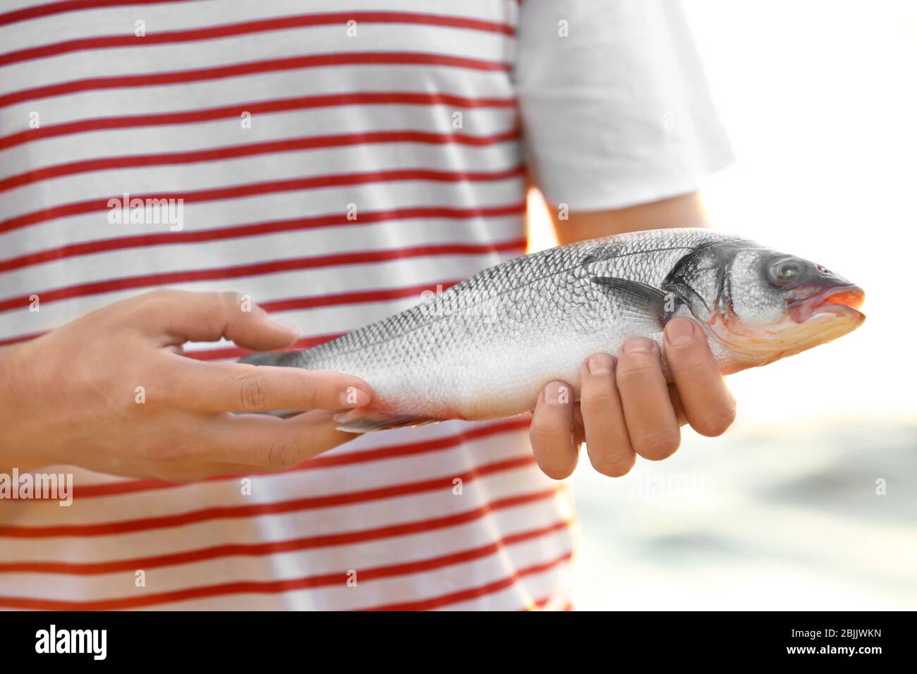 Man holding freshly caught fish Stock Photo - Alamy