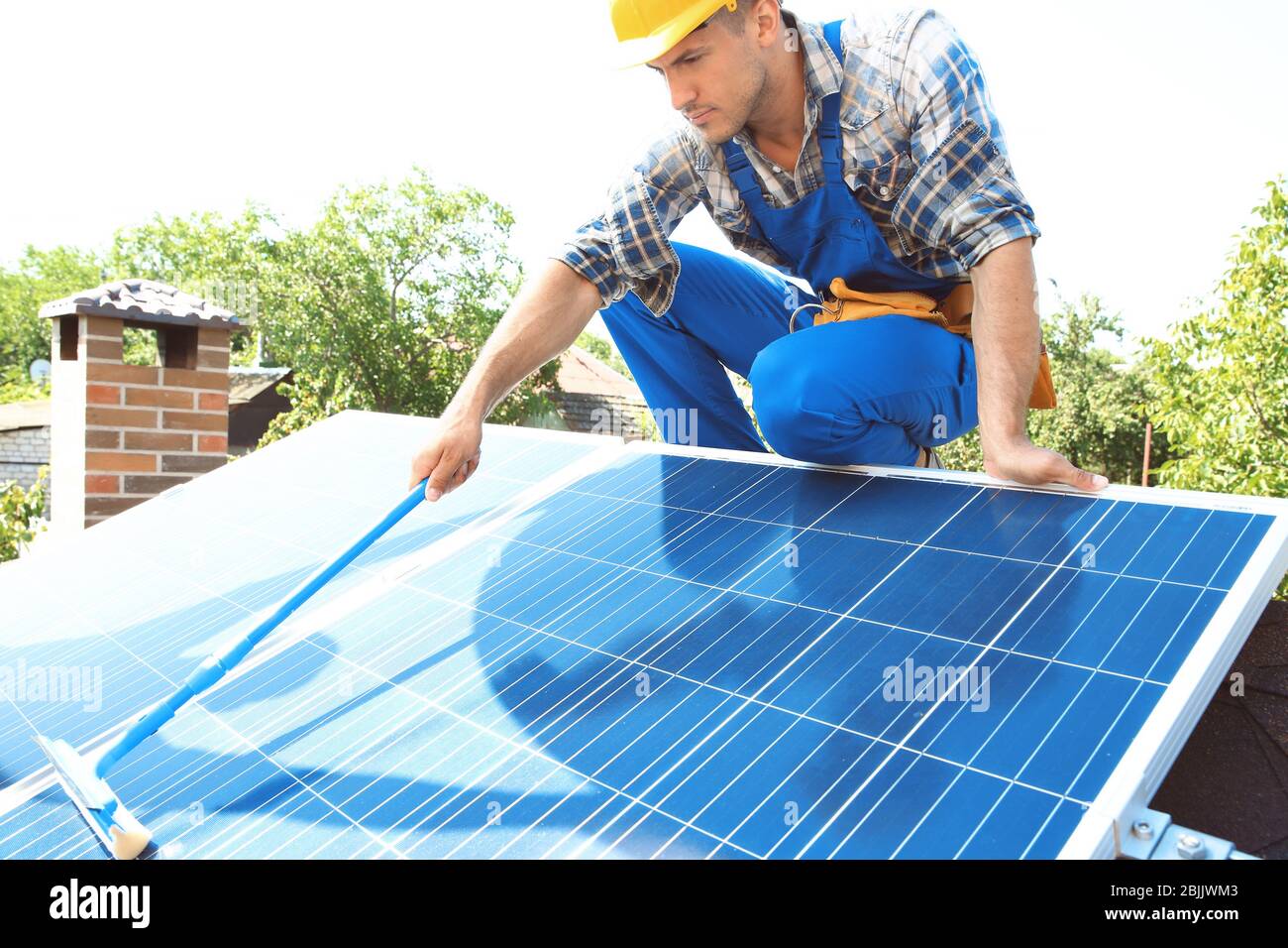 Worker cleaning solar panels after installation outdoors Stock Photo ...