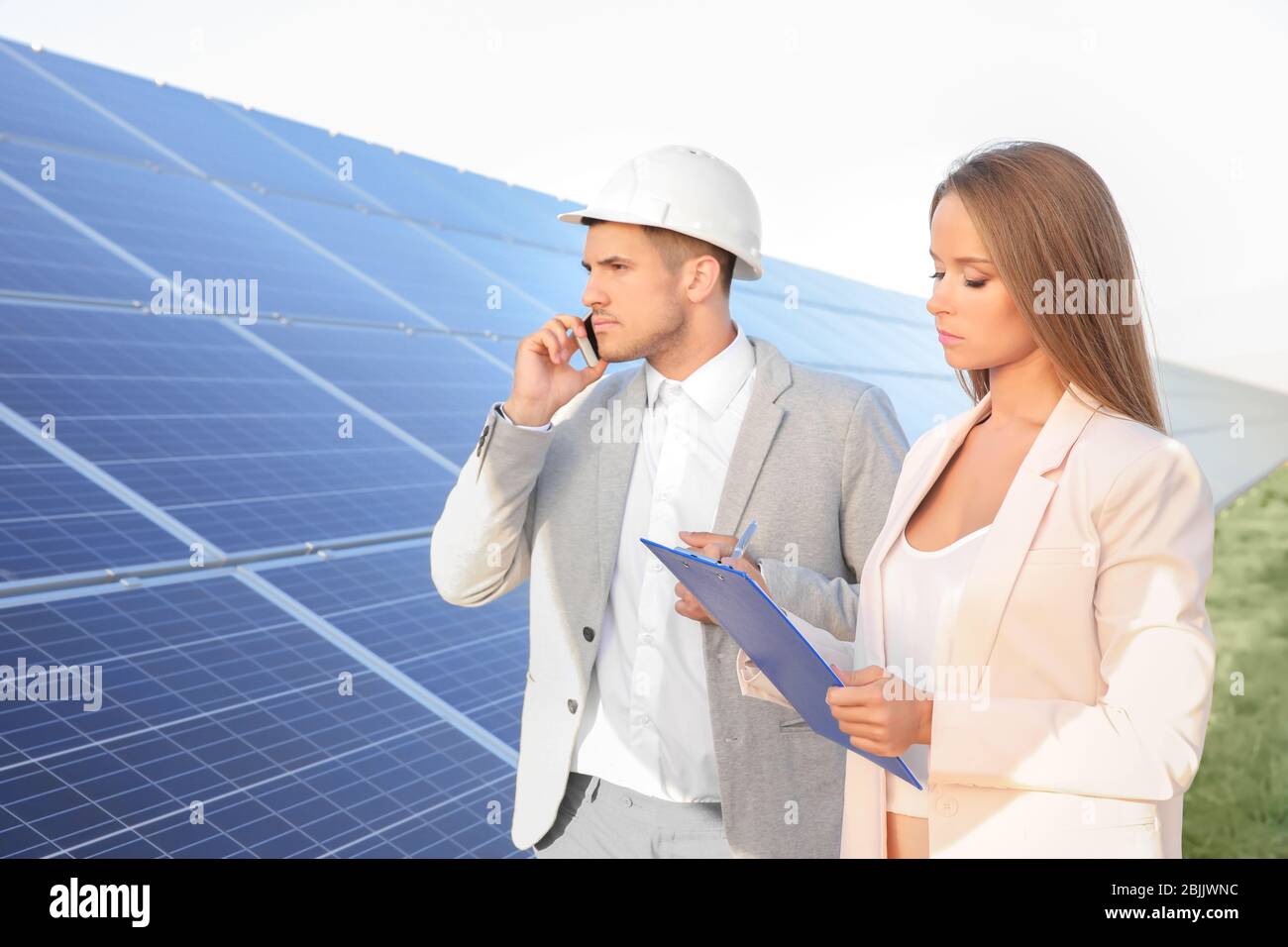 Engineers discussing project on installation of solar panels outdoors ...