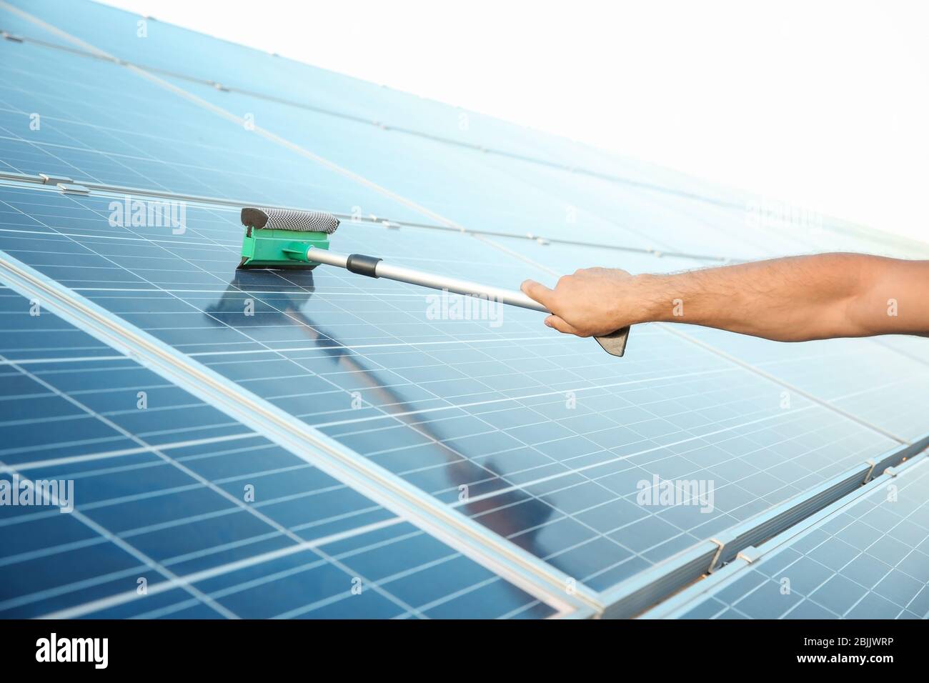 Hand of worker washing solar panels after installation outdoors Stock ...