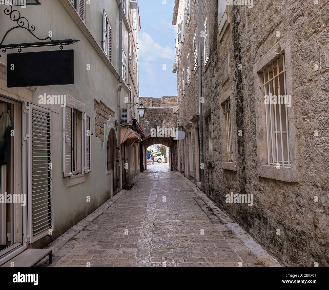 Picturesque small street with stone arch in old town Stock Photo - Alamy