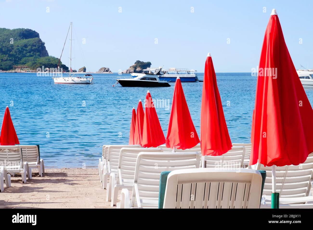 Empty sunbeds with umbrellas on beach Stock Photo - Alamy