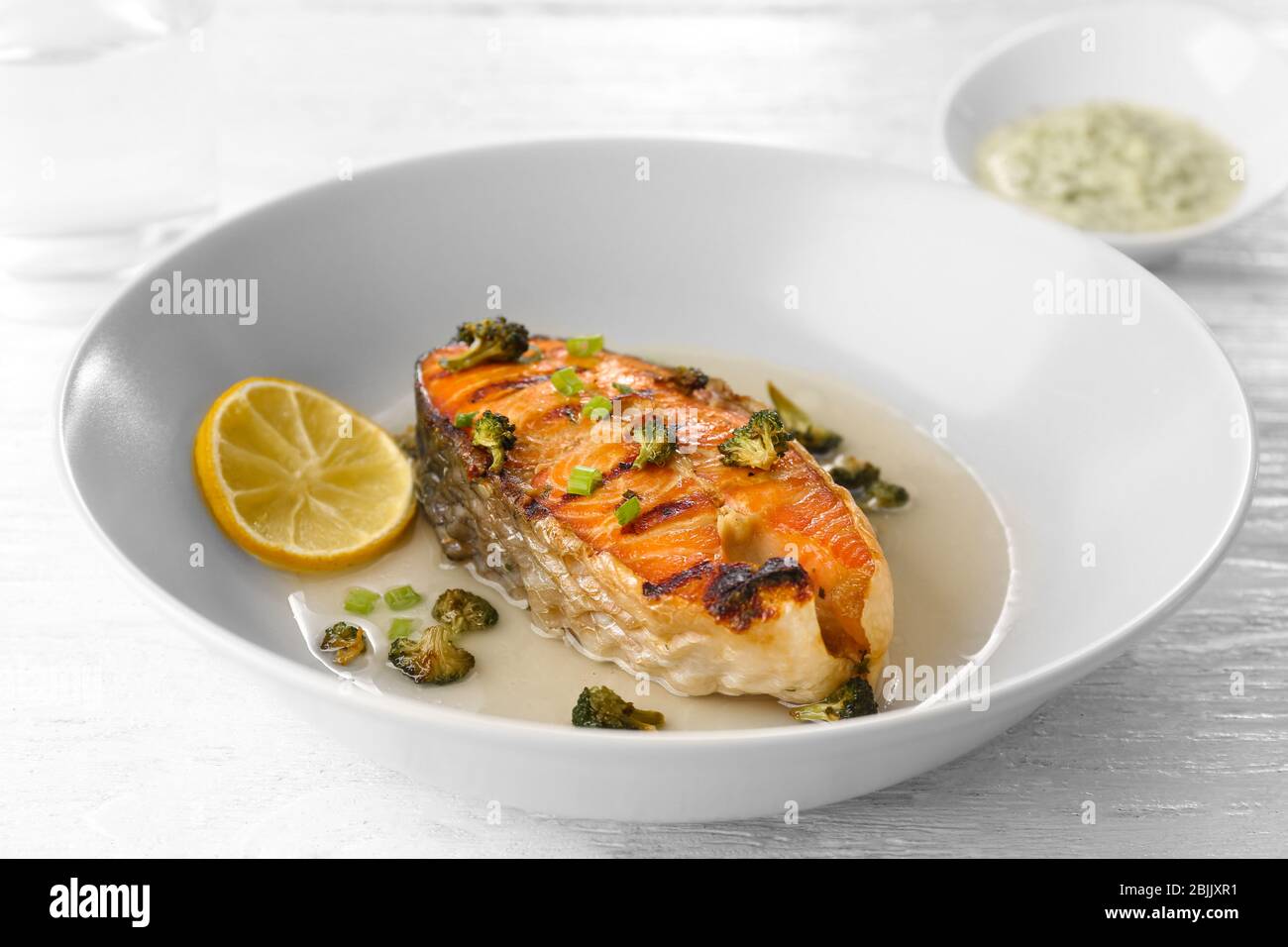 Plate of tasty fish with sauce on table Stock Photo - Alamy