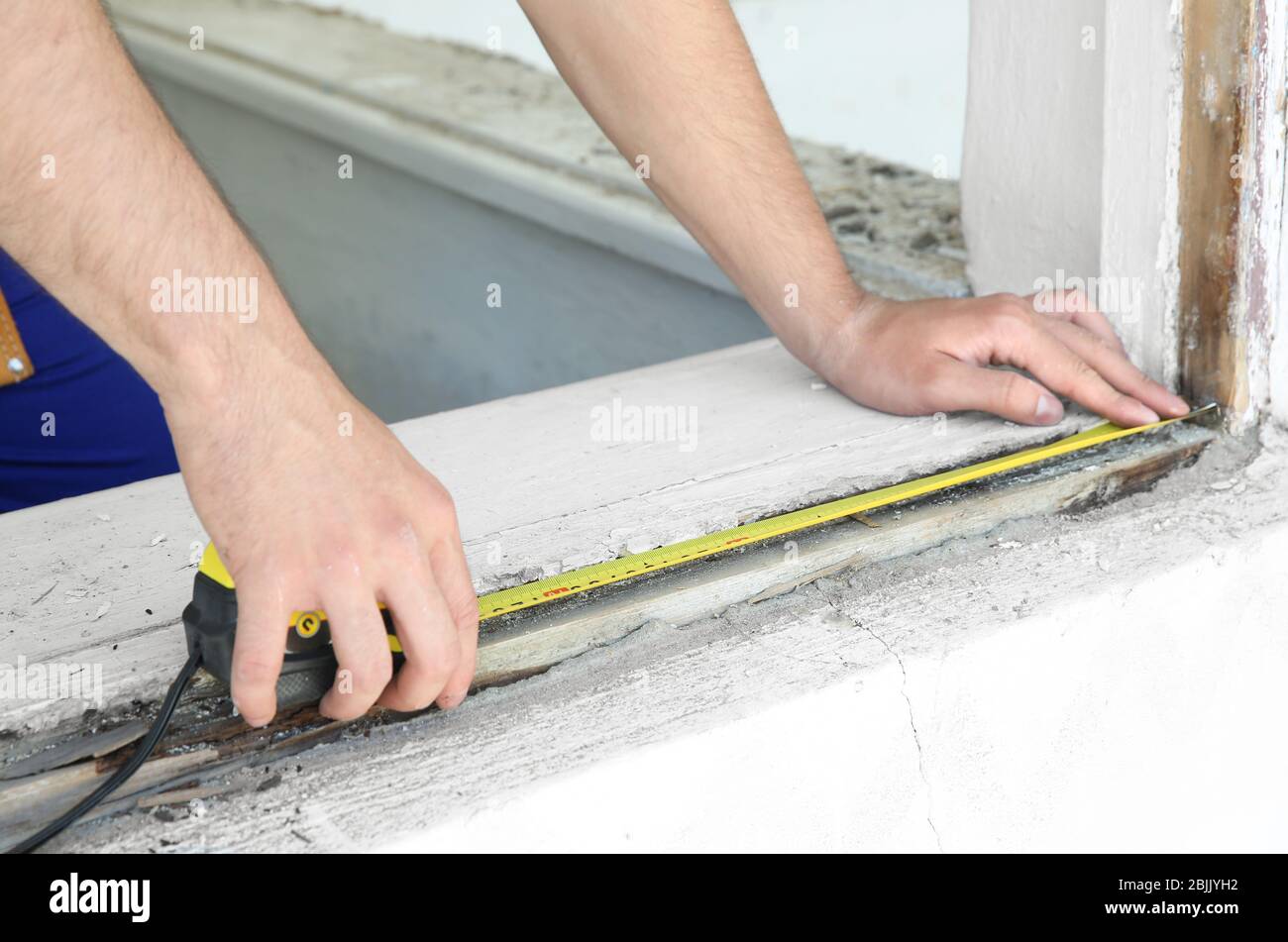 Worker repairing window in flat Stock Photo - Alamy