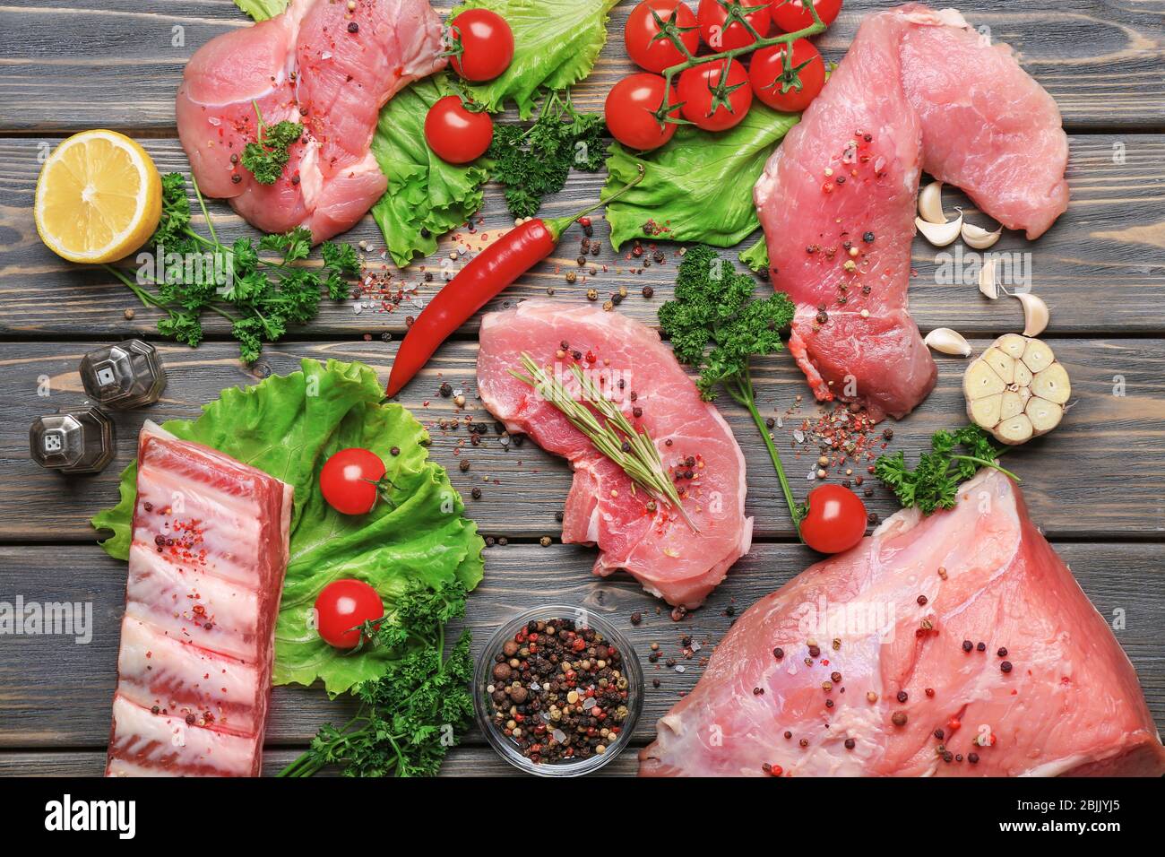 Different types of meat on wooden table Stock Photo - Alamy