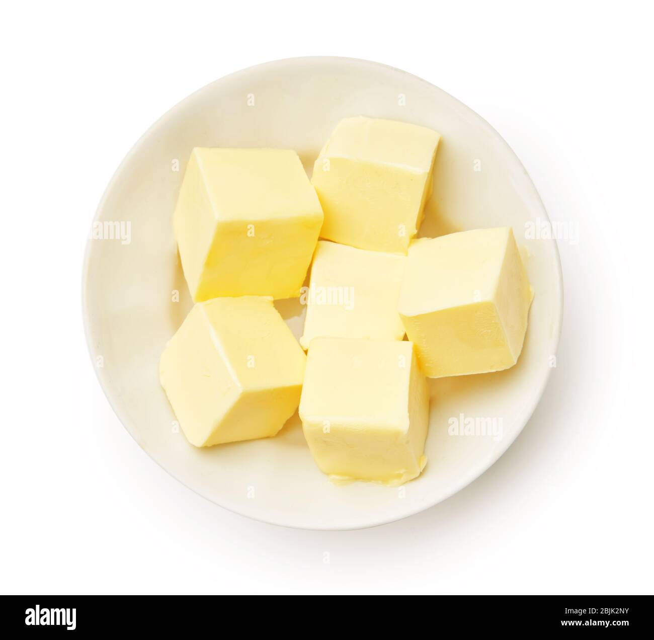 Butter pieces in white bowl isolated. Butter cubes. Top view Stock ...