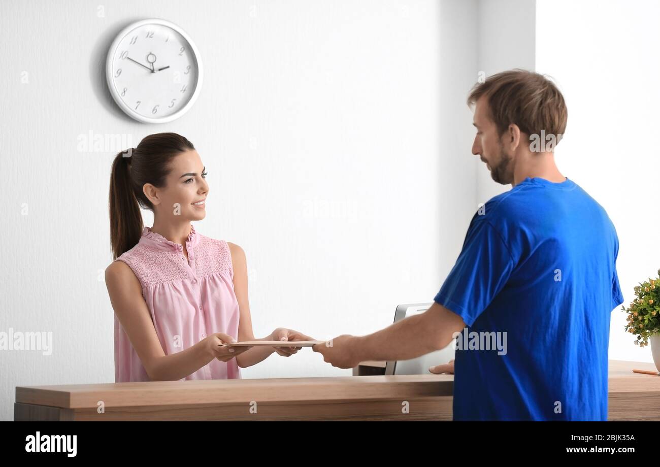 Young female receptionist meeting client in office Stock Photo - Alamy