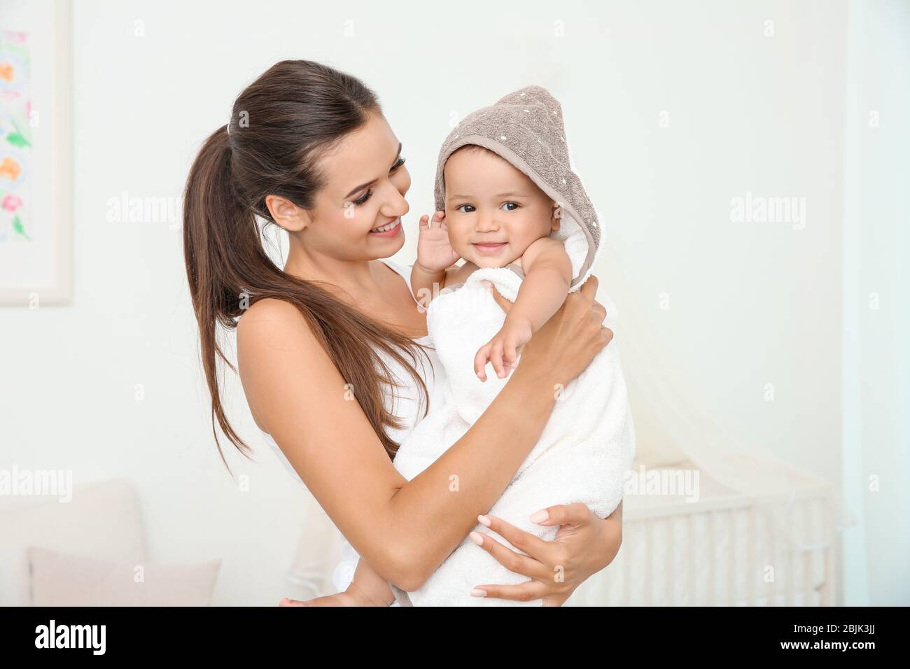 Mother holding cute baby in towel after bathing at home Stock Photo - Alamy