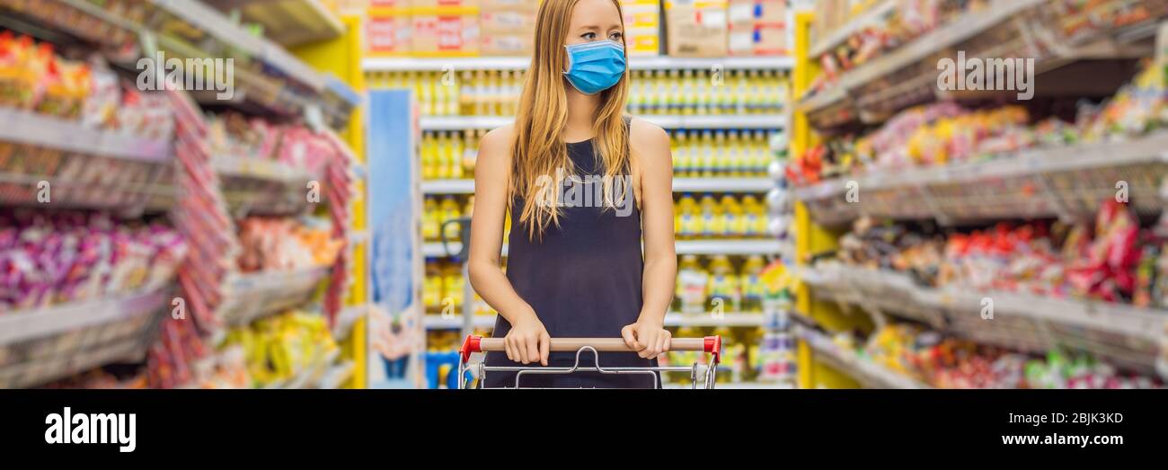 Alarmed female wears medical mask against coronavirus while grocery ...