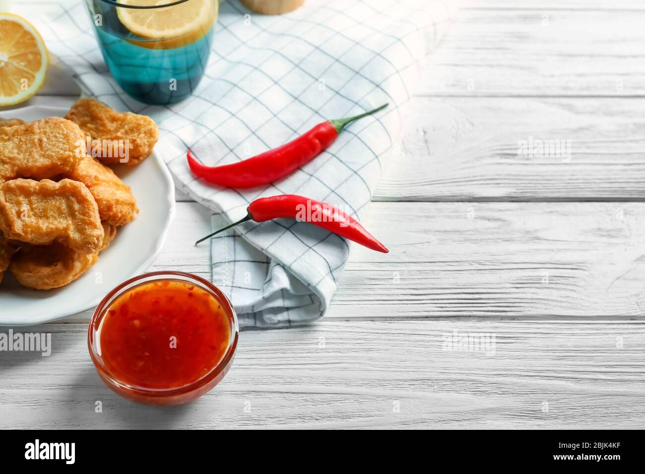 Chicken nuggets served with chili sauce on wooden table Stock Photo - Alamy