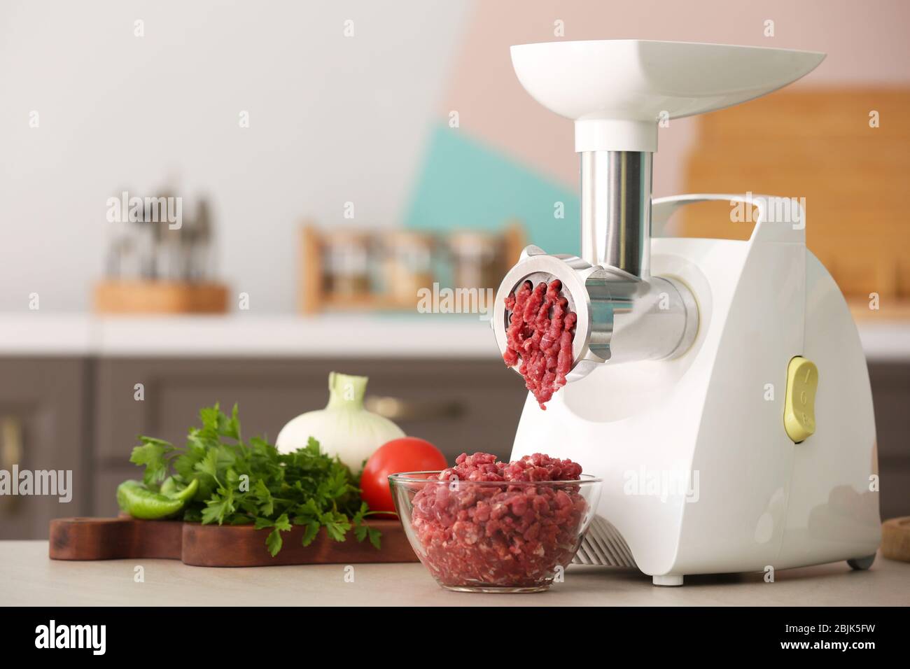 Meat grinder with fresh forcemeat on kitchen table Stock Photo - Alamy