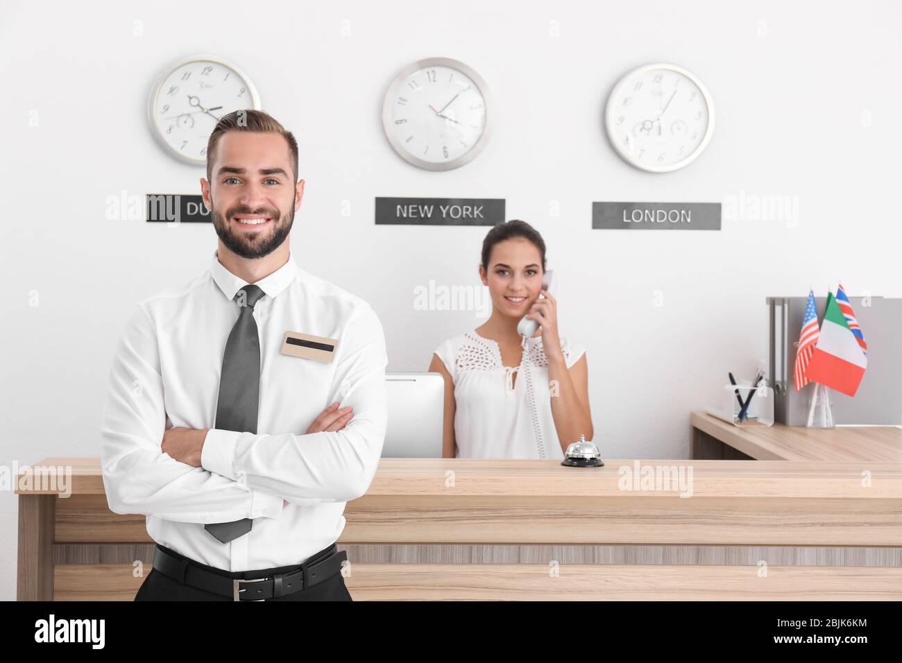 Two hotel receptionists at workplace Stock Photo - Alamy