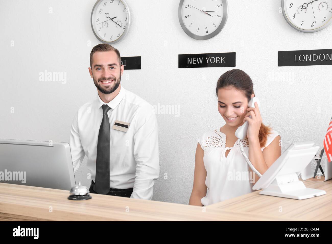 Two hotel receptionists at workplace Stock Photo - Alamy