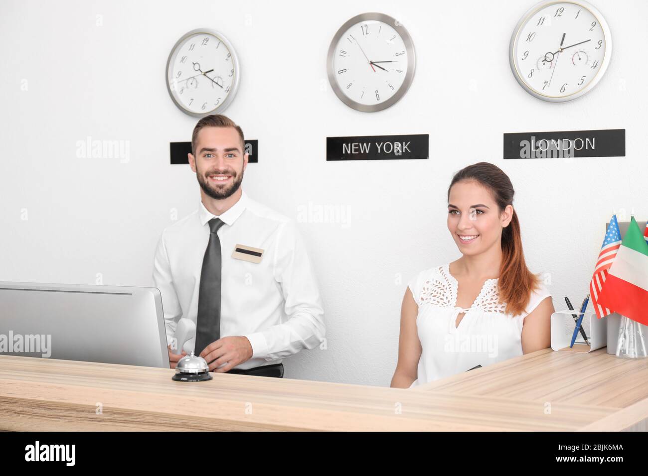 Two hotel receptionists at workplace Stock Photo - Alamy