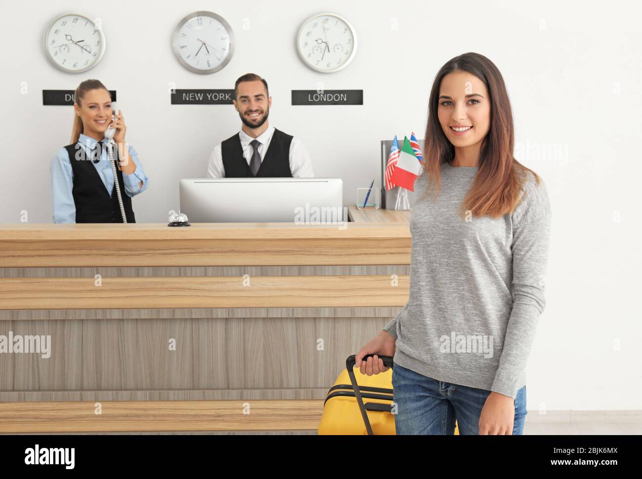 Young woman and two receptionists in hotel Stock Photo - Alamy