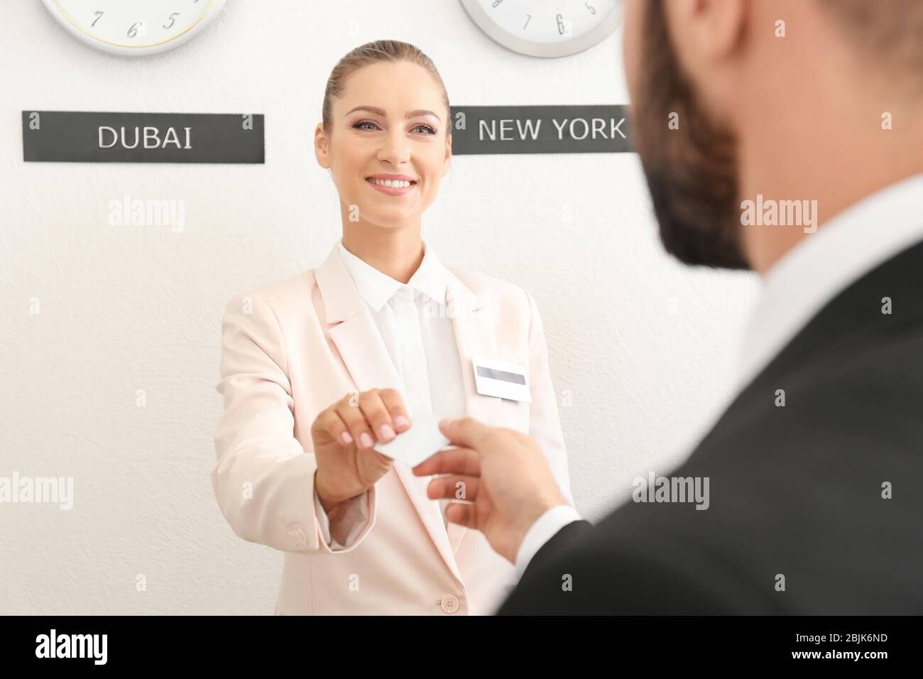 Female receptionist handing card to customer in hotel Stock Photo - Alamy