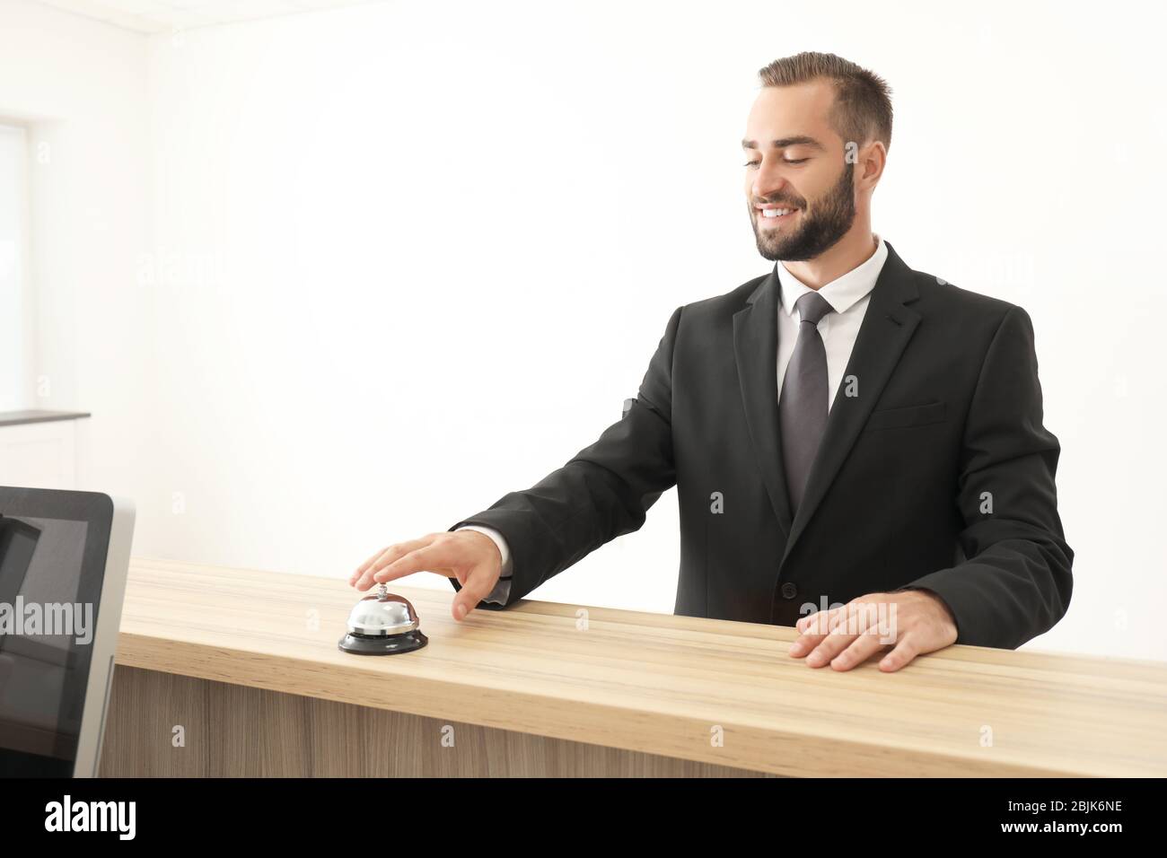 Man ringing in service bell on reception desk Stock Photo - Alamy