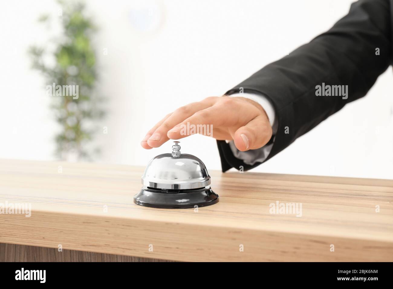 Man ringing in service bell on reception desk Stock Photo - Alamy