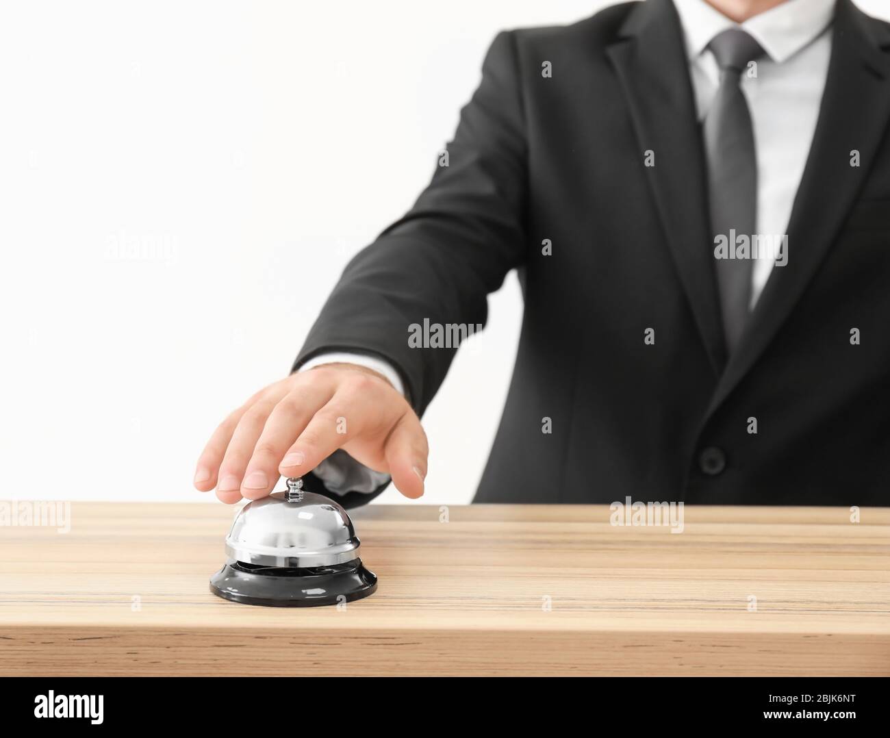 Man ringing in service bell on reception desk Stock Photo - Alamy