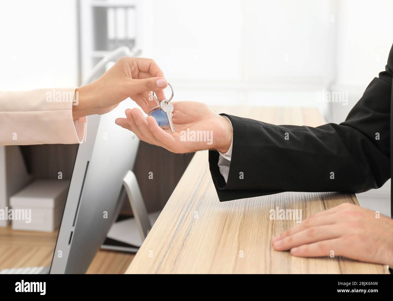 Female receptionist handing room key to customer in hotel Stock Photo ...