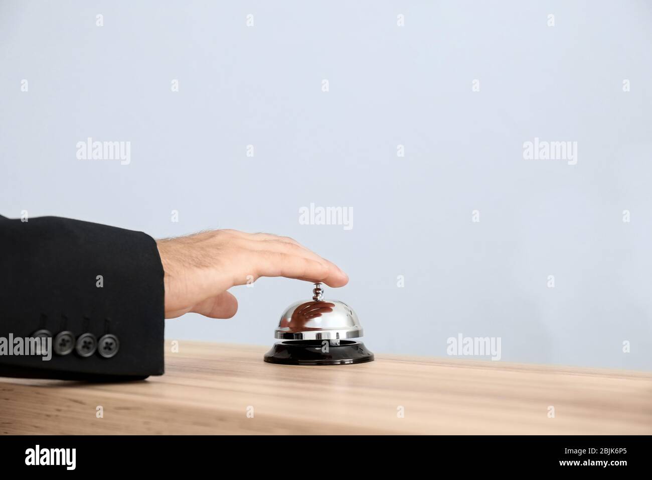 Man ringing in service bell on reception desk Stock Photo - Alamy