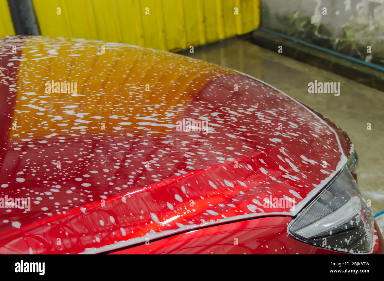 Car cleaning service. Red modern car with Foam at carcare Stock Photo ...