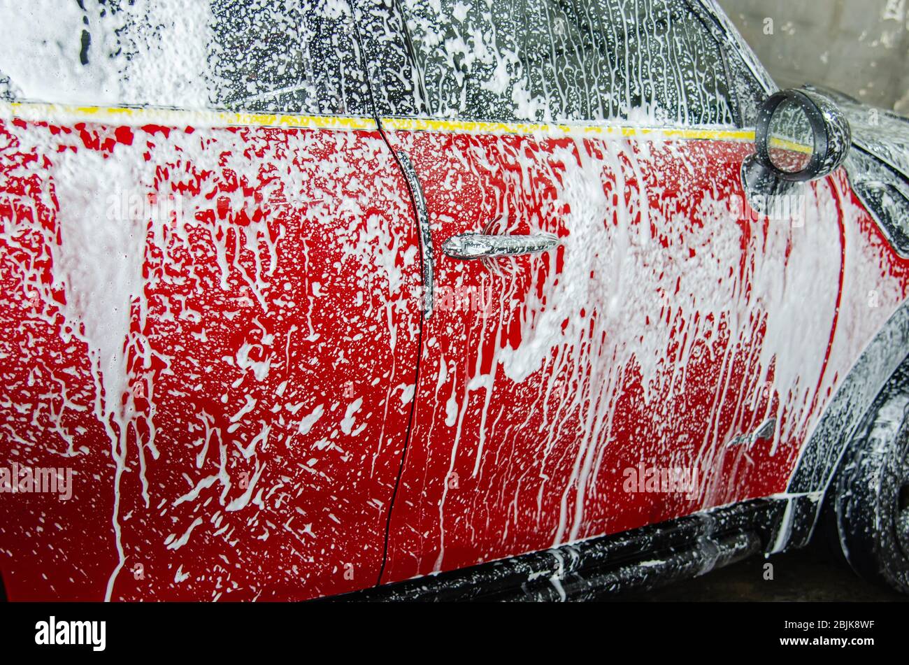 Cleaning red cars. Wash the car at the car wash station with foam ...