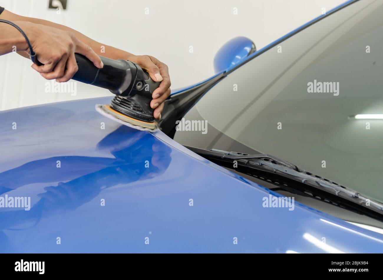 Auto polishing with machine.Blue car polish to remove and recover the ...