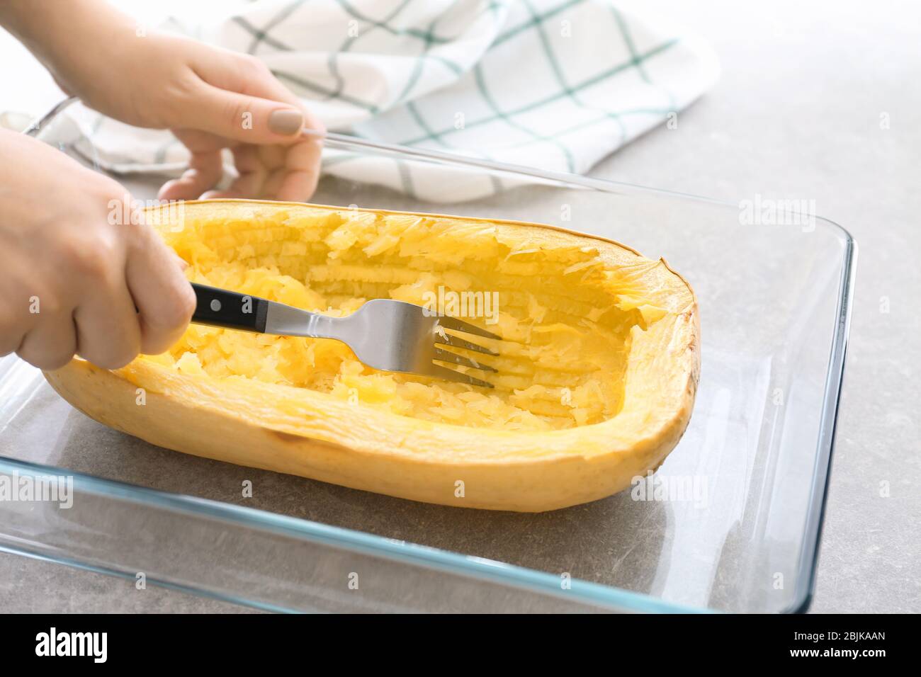 Woman preparing spaghetti squash in kitchen Stock Photo - Alamy