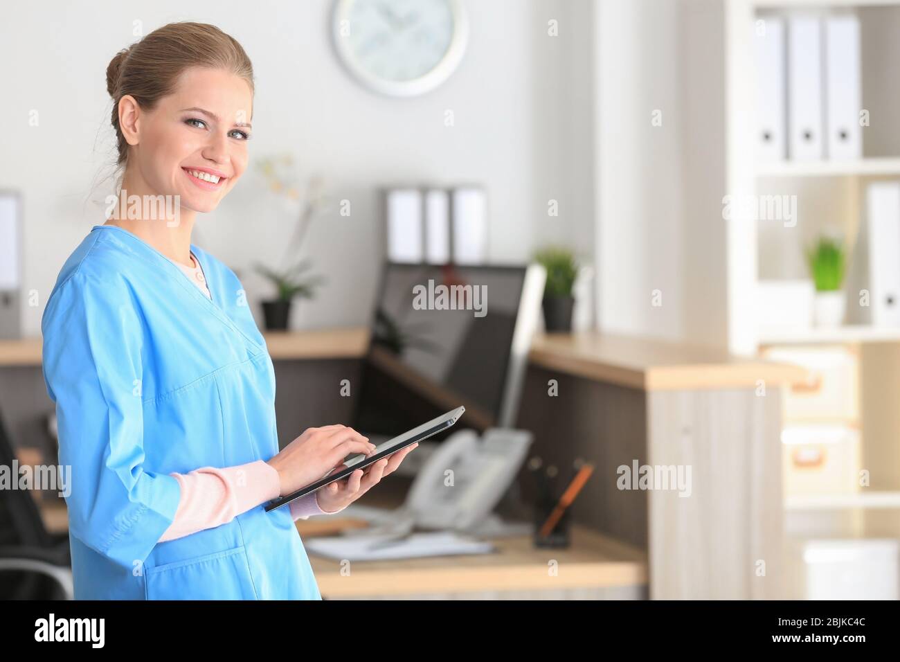 Young female receptionist holding tablet computer in hospital Stock ...