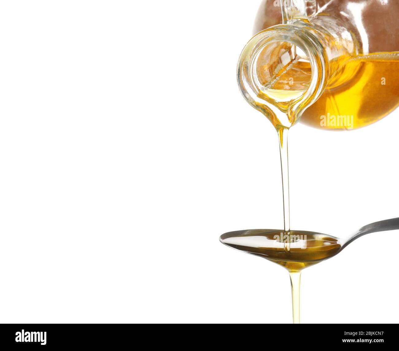 Pouring cooking oil into spoon, on white background Stock Photo - Alamy