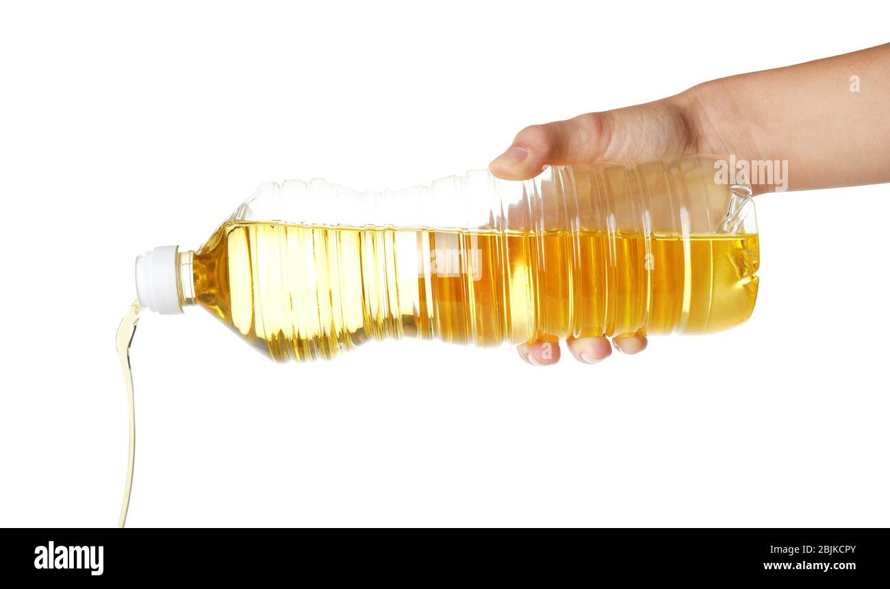 Hand of woman pouring cooking oil from plastic bottle, on white ...