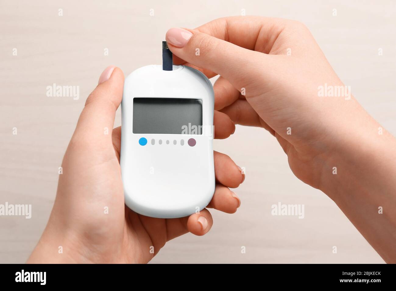 Woman's hands using digital glucometer on light background. Diabetes ...
