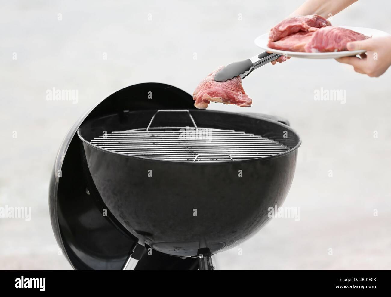 Woman cooking tasty steaks on barbecue grill, closeup Stock Photo - Alamy