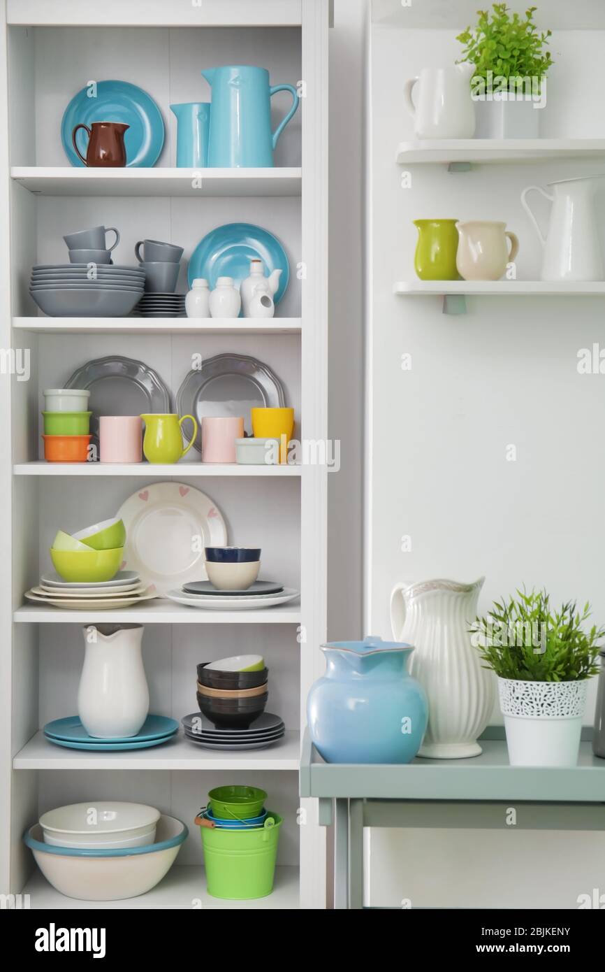White storage stand with colorful ceramic dishware indoors Stock Photo ...