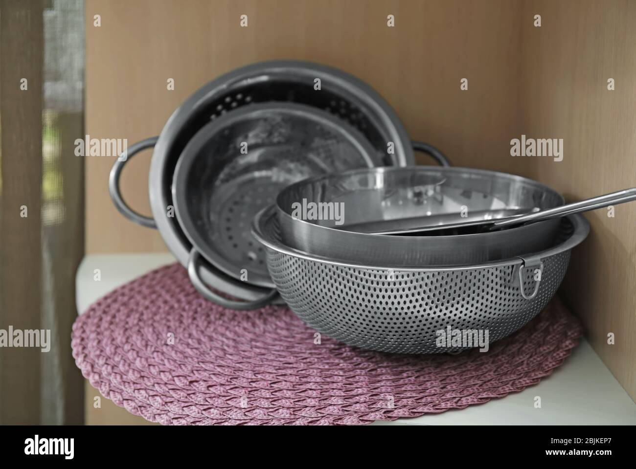 Metal kitchenware on shelf indoors Stock Photo - Alamy