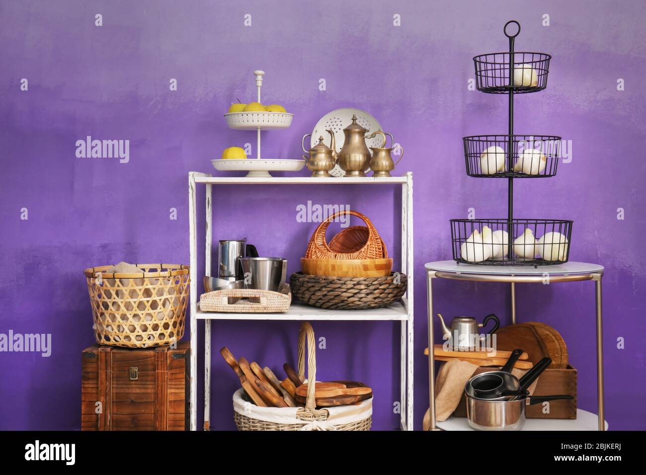 White storage stand with kitchenware near color wall Stock Photo - Alamy