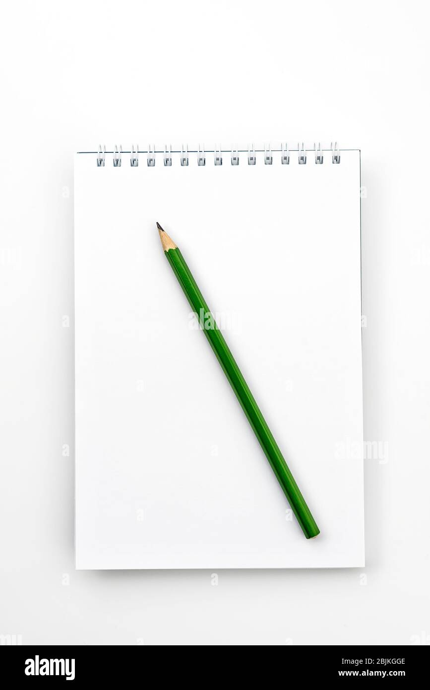 Open notebook with green Graphite pencil on a white office table Stock ...