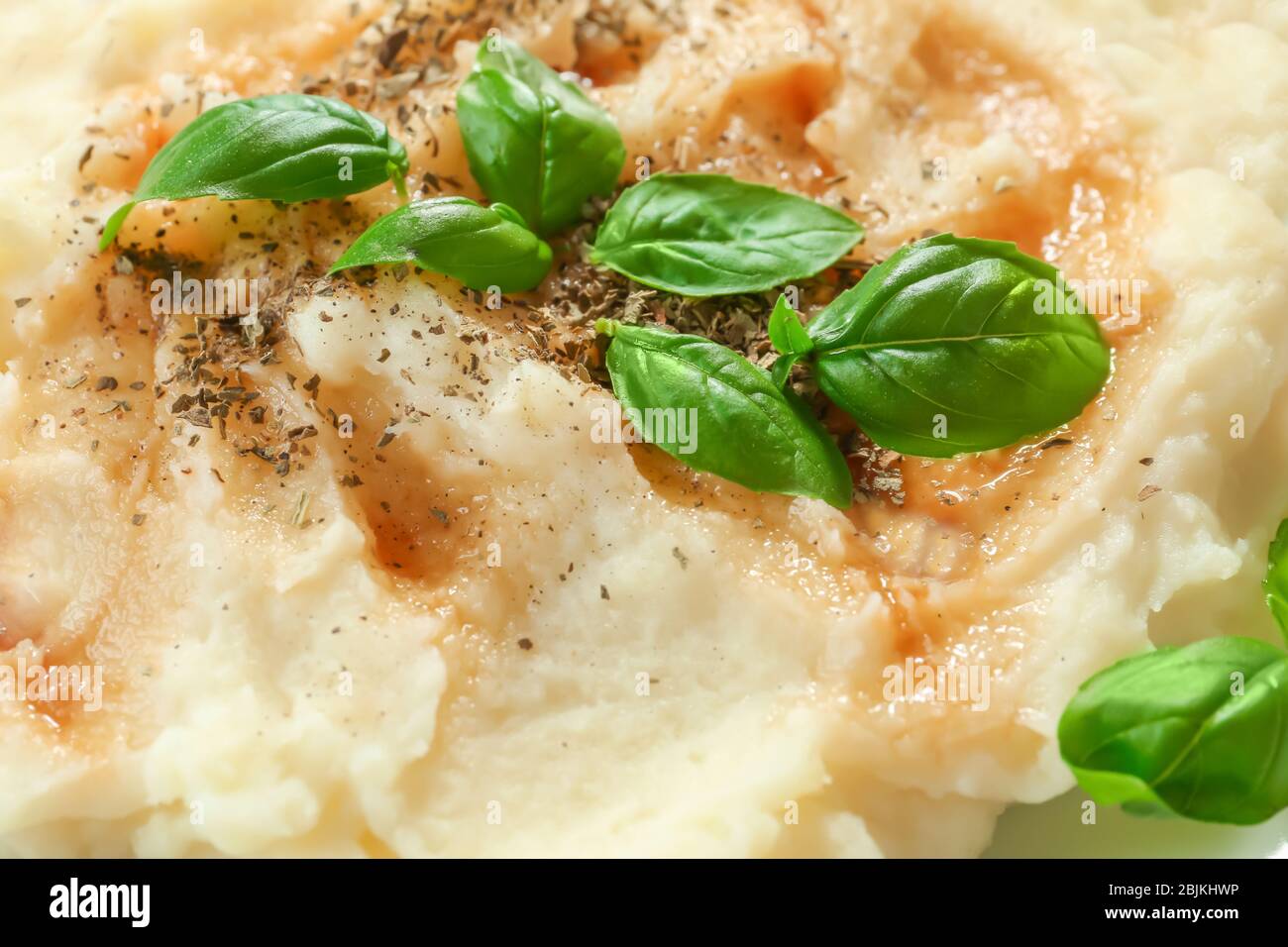 Mashed potatoes with basil and gravy, closeup Stock Photo - Alamy