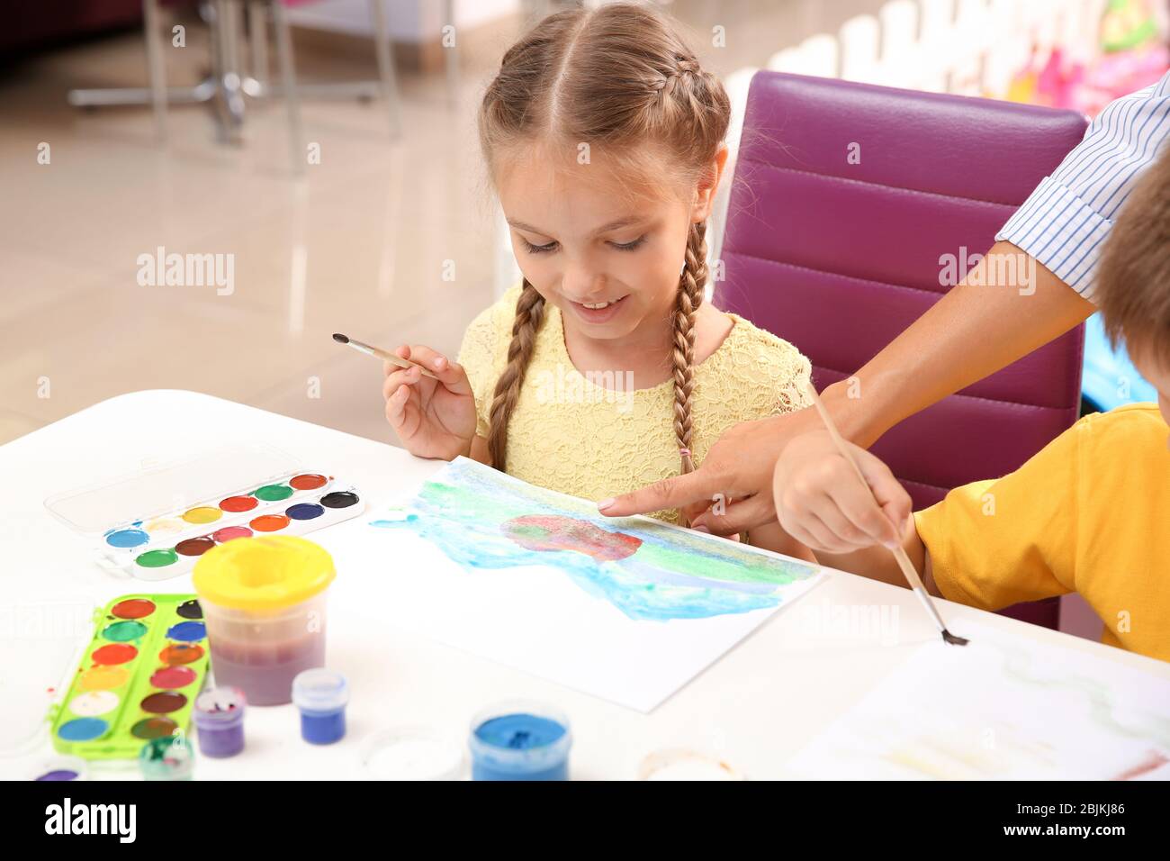 Little girl at painting lesson in classroom Stock Photo - Alamy