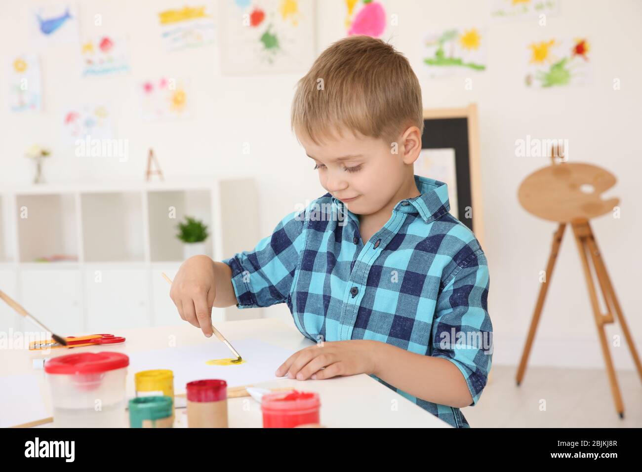 Little boy at painting lesson in classroom Stock Photo - Alamy