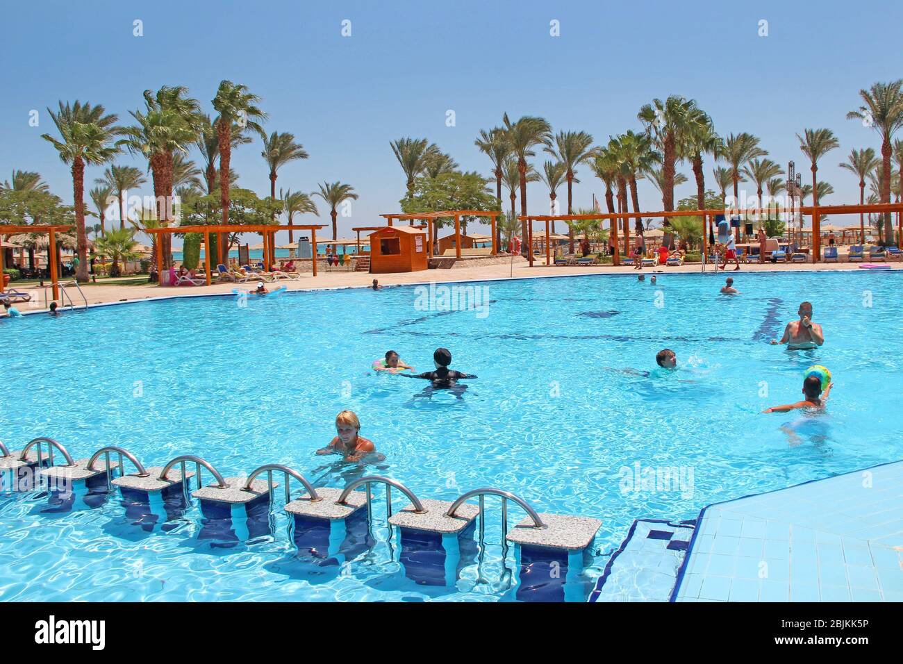 Tourists enjoy relaxing at tropical resort in pool in Egypt. Swimming ...