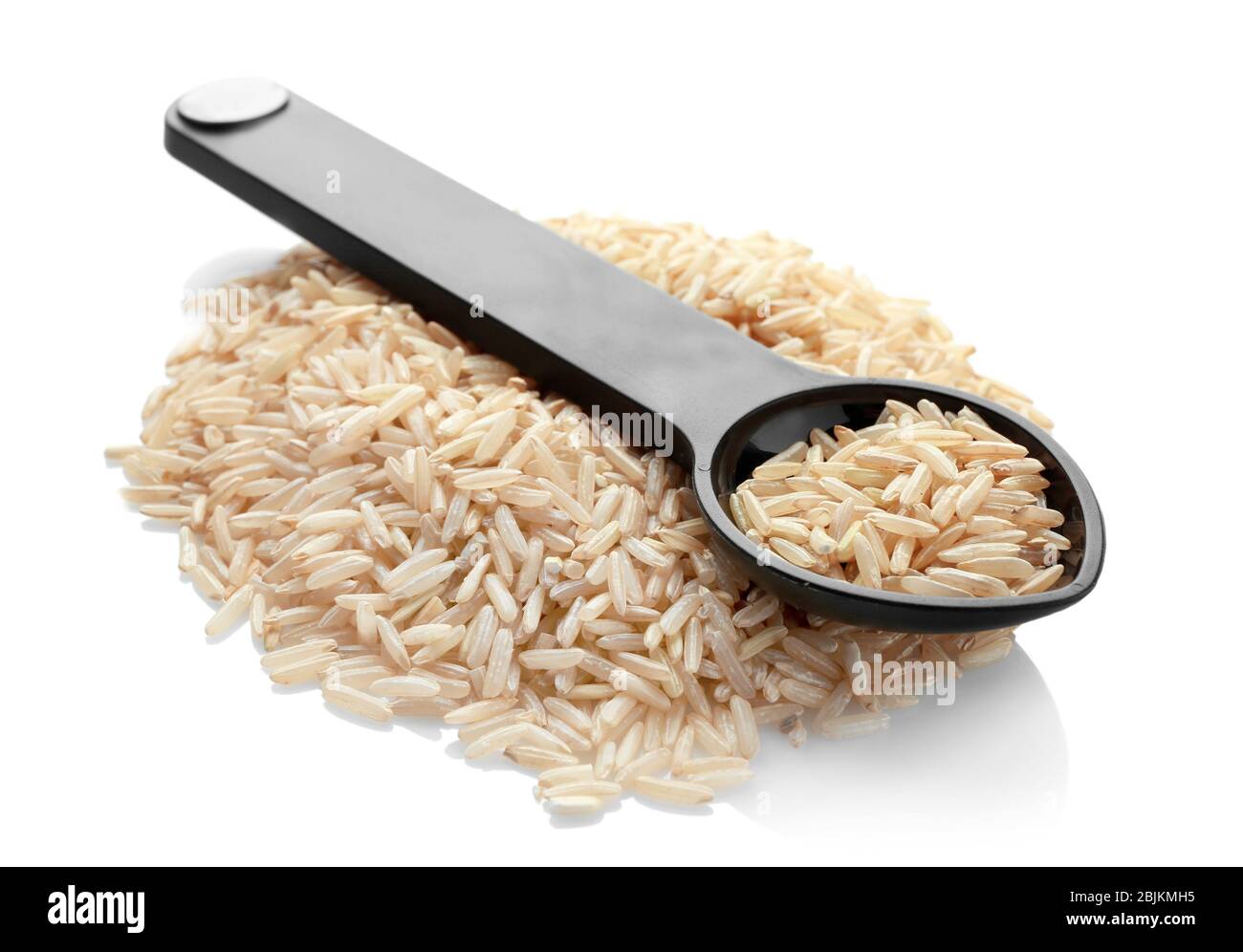 Measuring spoon and heap of brown rice on white background Stock Photo ...