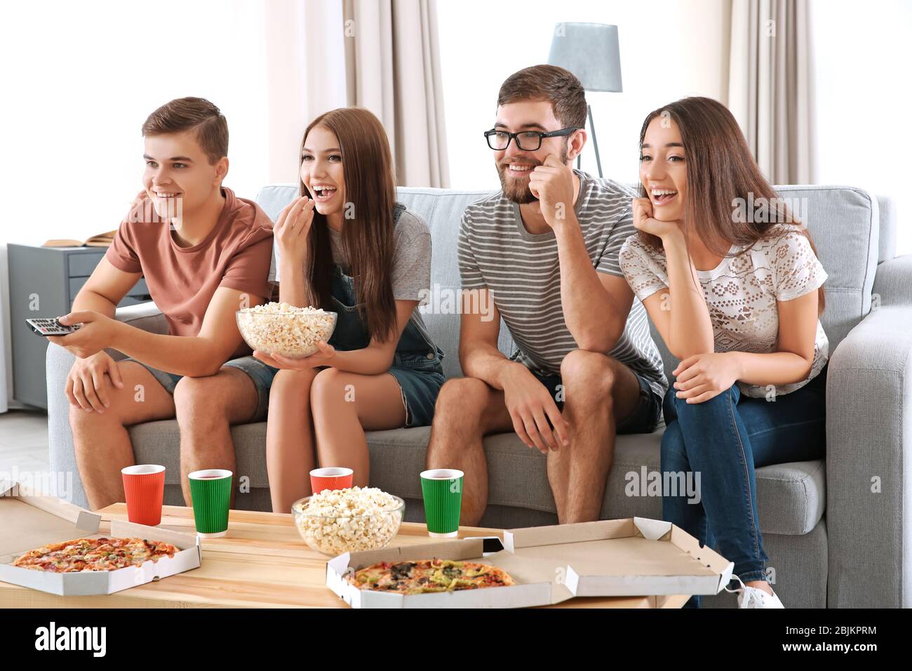 Friends watching TV at home Stock Photo - Alamy